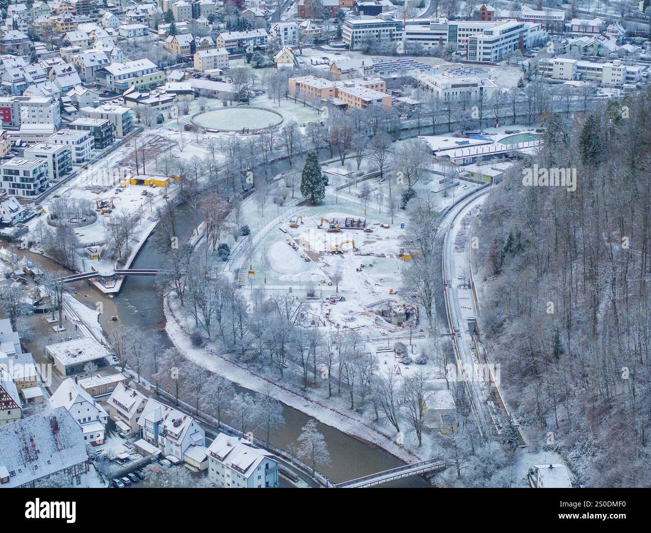 Snowy city with river, surrounded by trees and buildings, showing ...