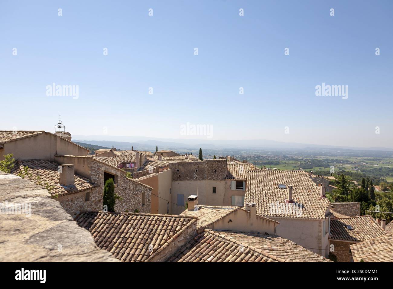 Historic village under a blue sky with terracotta roofs and a sweeping ...