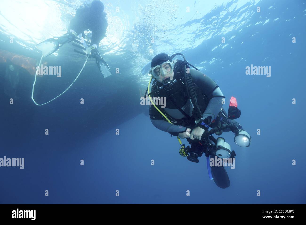 Diver under water with complete equipment waiting until the ladder back ...