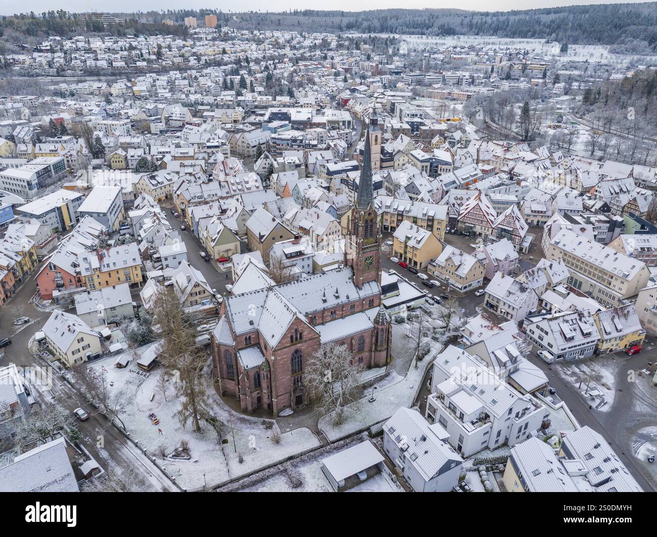 Townscape in winter with snow-covered roofs and a central church ...