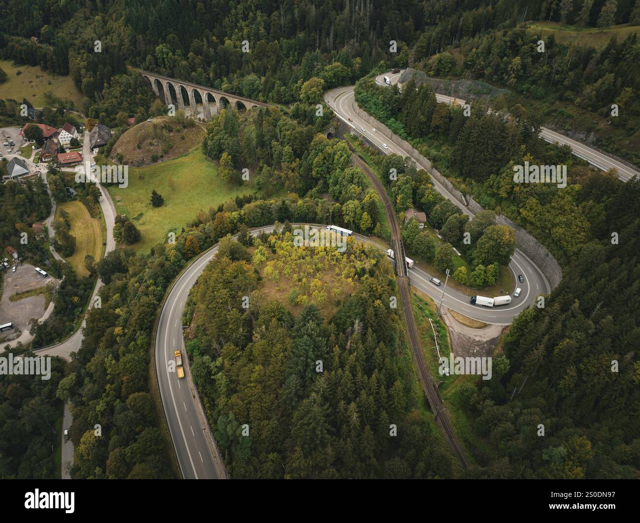 Winding road through forest and viaduct in hilly landscape, Ravenna ...
