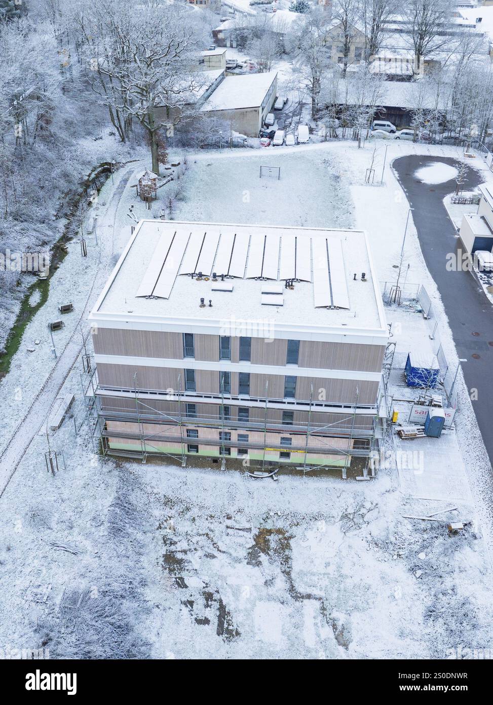 A snow-covered building with scaffolding in an urban residential area ...