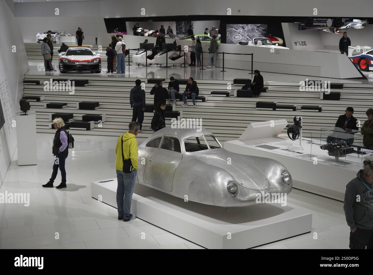 Porsche Type 64, built in 1939, visitors look at a silver prototype car ...