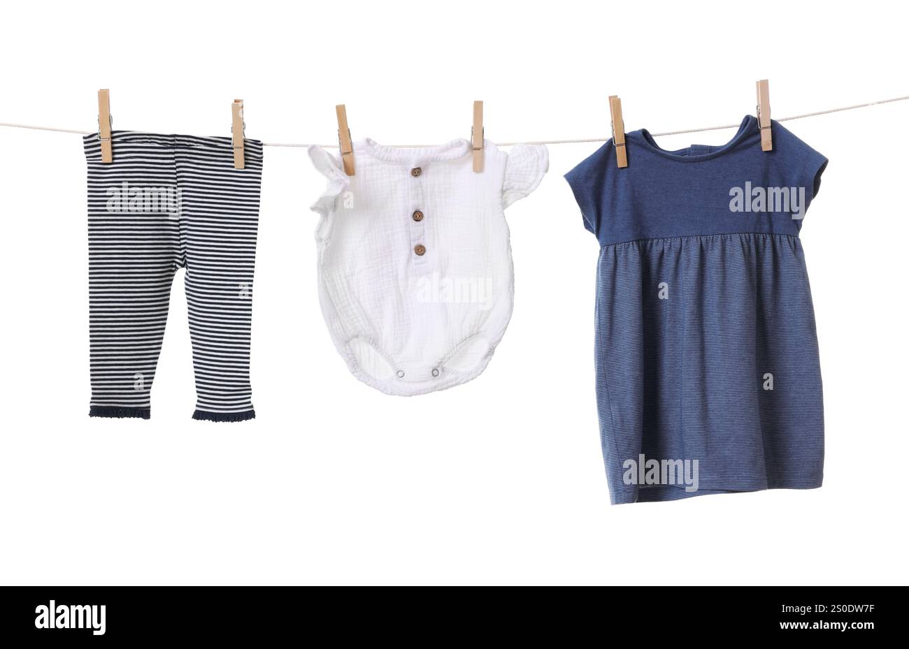 Different baby clothes drying on laundry line against white background ...