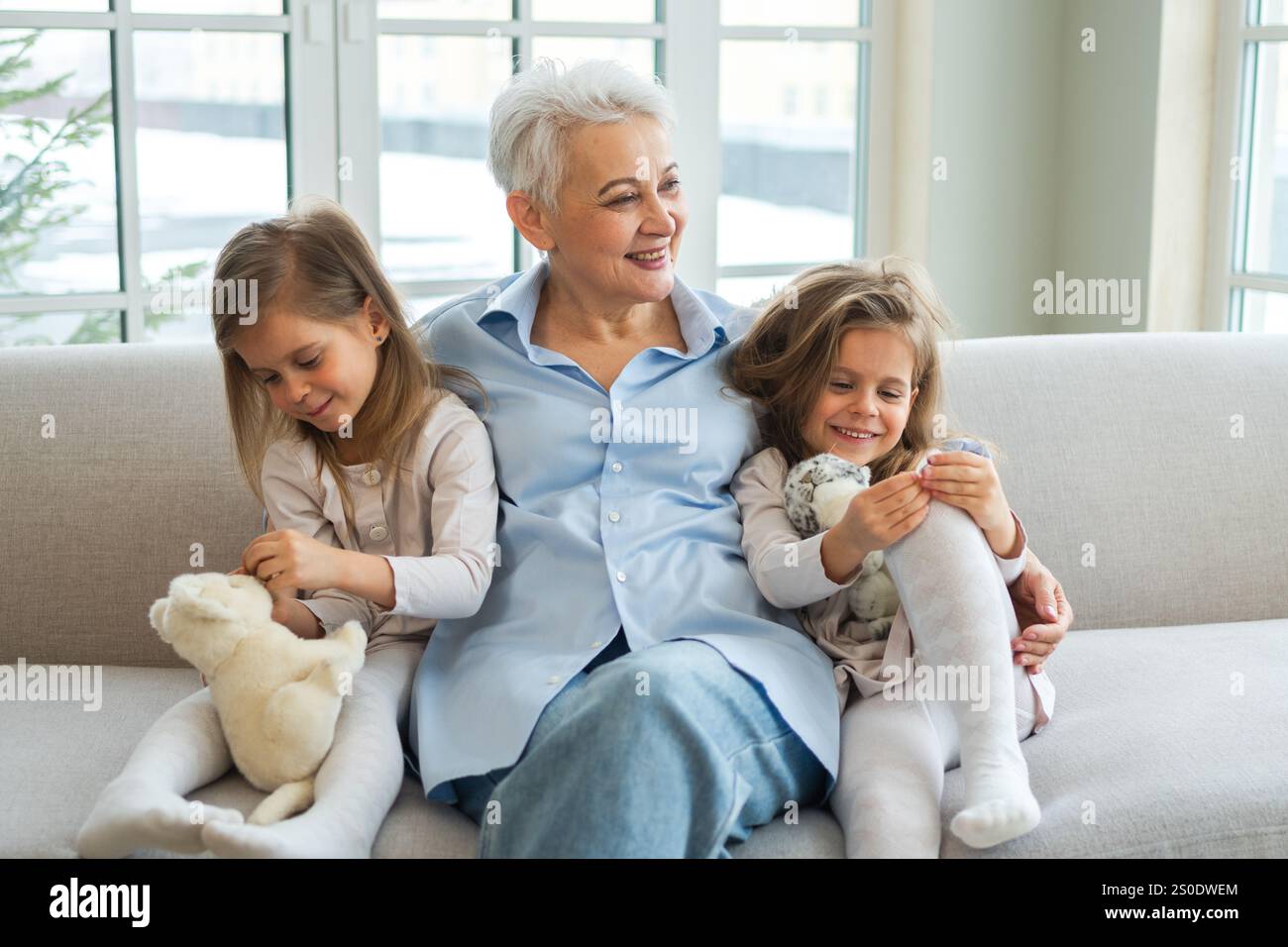 Happy family at home. Two little girls sisters twins grandmother ...
