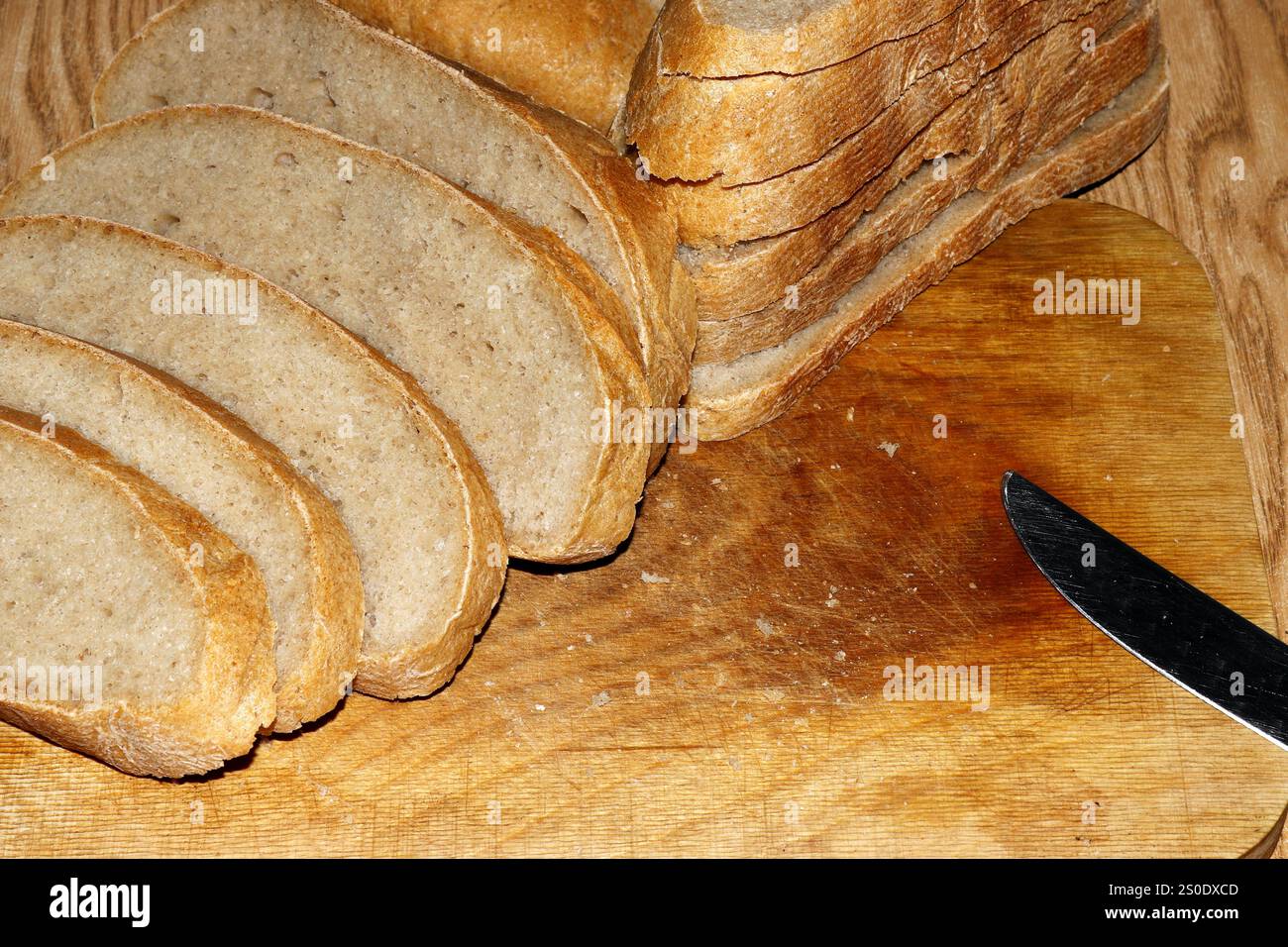 Image of a loaf of bread cut into slices on a kitchen board Stock Photo ...