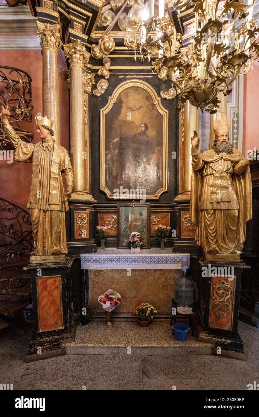 A gold and black church with two statues of men on either side of a ...