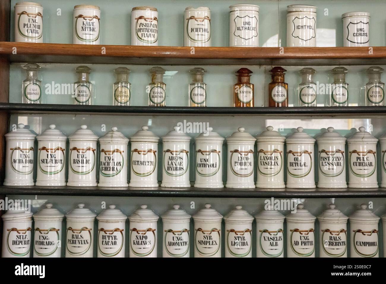A shelf full of glass jars with labels on them. The jars are of various ...