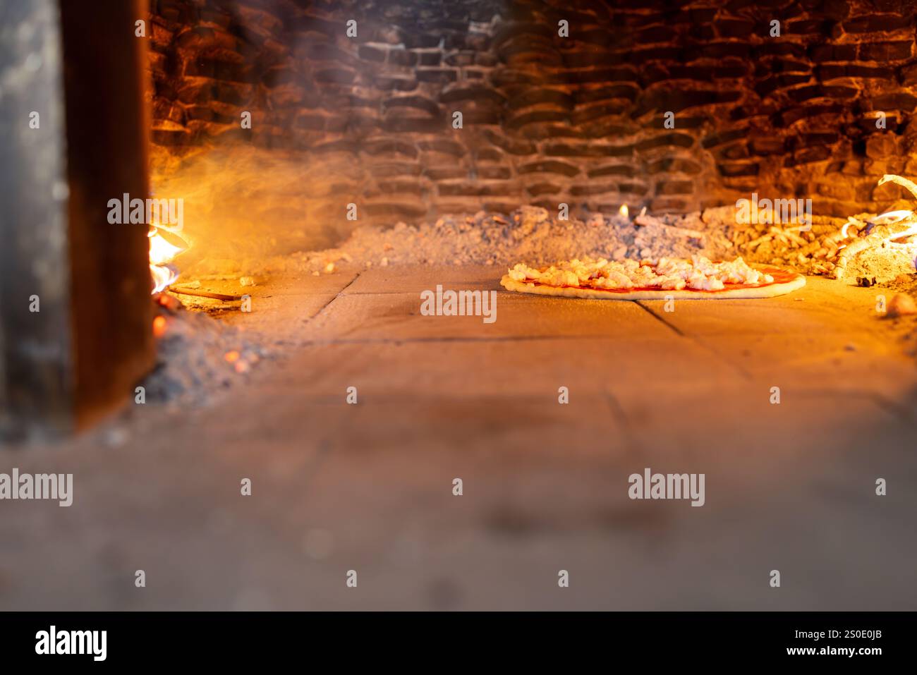 A close-up view of a pizza baking inside a rustic wood-fired oven Stock Photo - Alamy