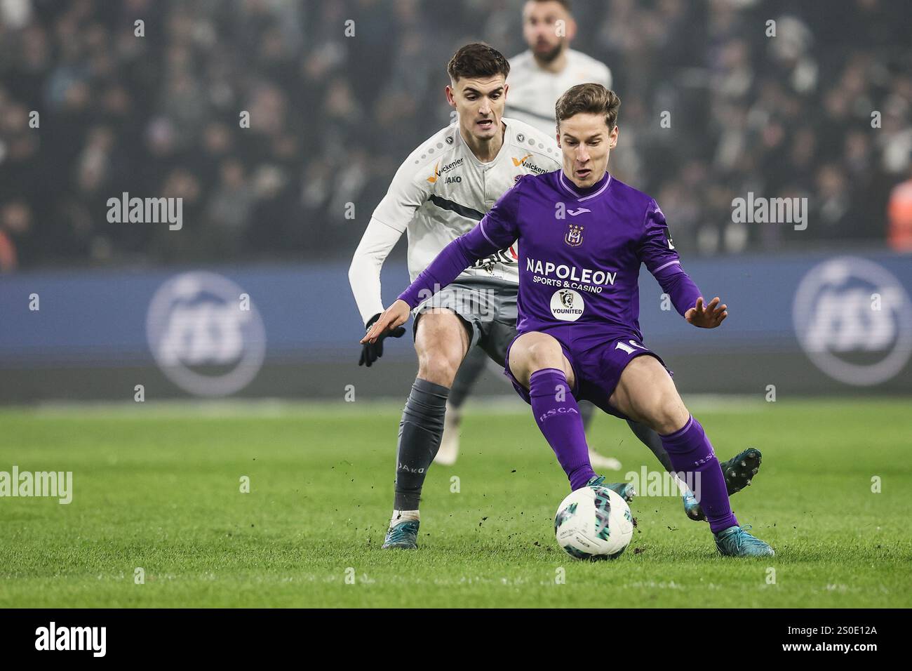 Brussels, Belgium. 27th Dec, 2024. Dender's Nathan Rodes and Anderlecht's Yari Verschaeren fight ...