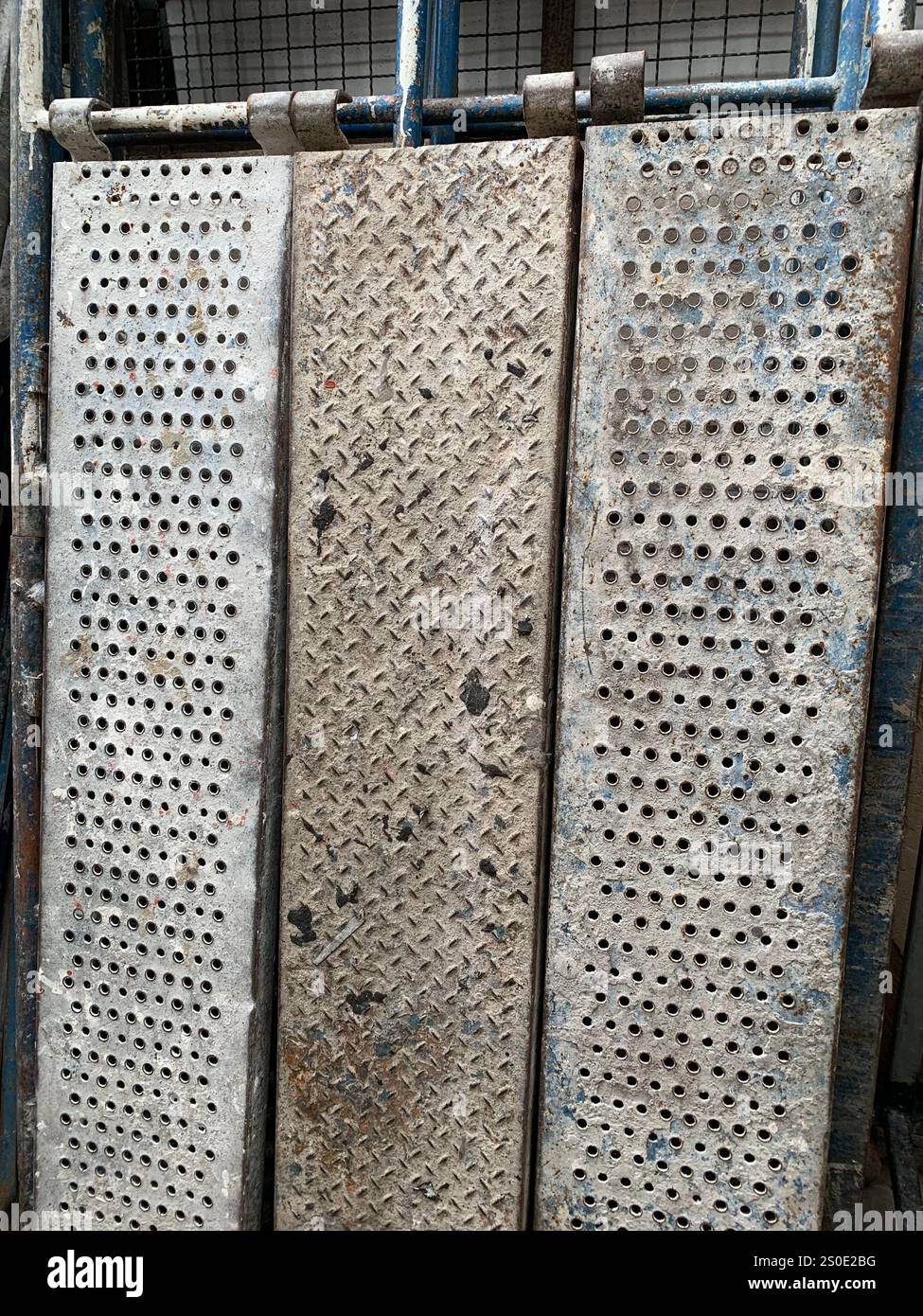 Three hanging old perforated metal plaques Stock Photo - Alamy