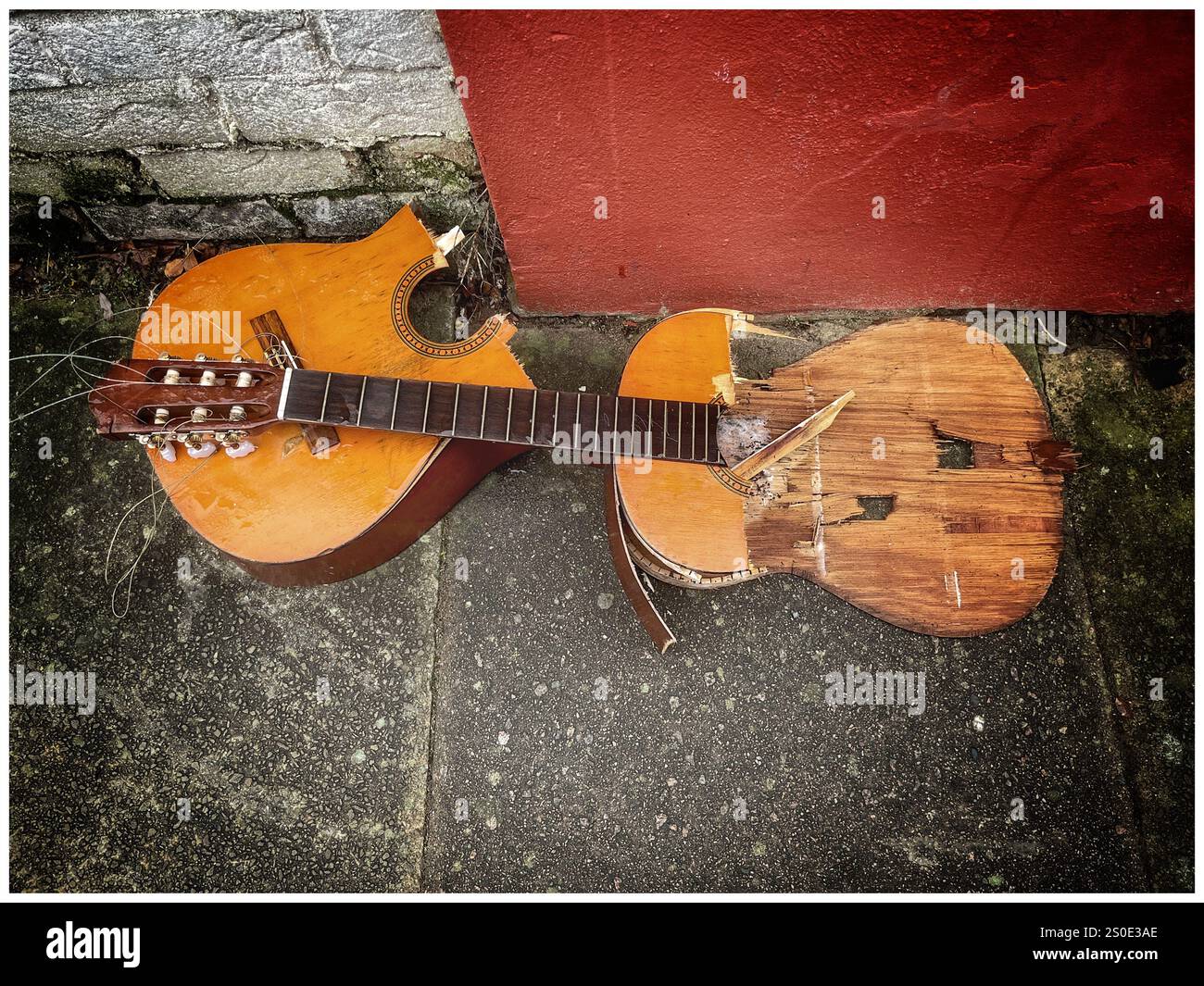 A broken acoustic guitar dumped on the pavement Stock Photo - Alamy