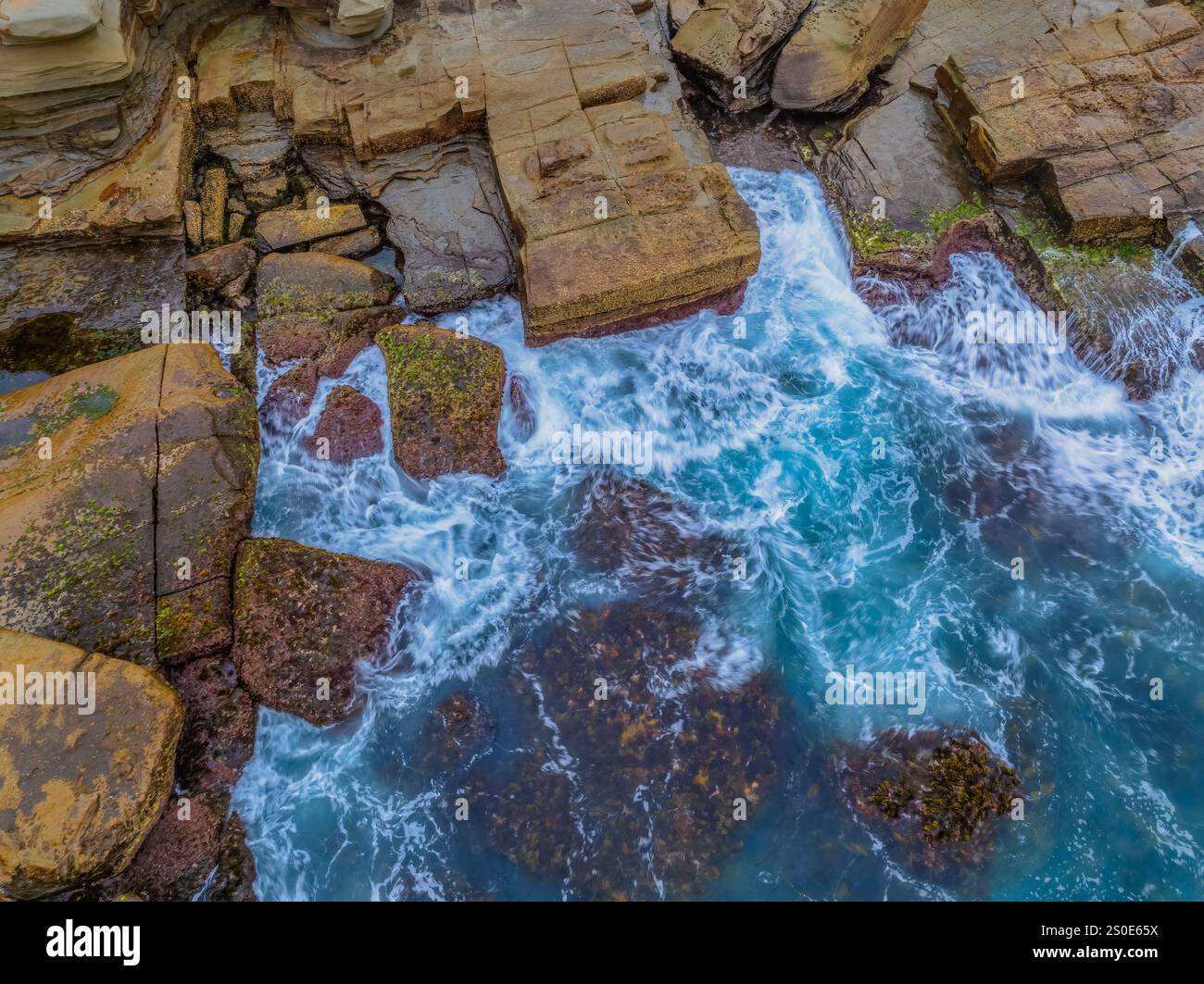 Aerial sunrise seascape looking down at the rocks at The Skillion in Terrigal, NSW, Australia ...