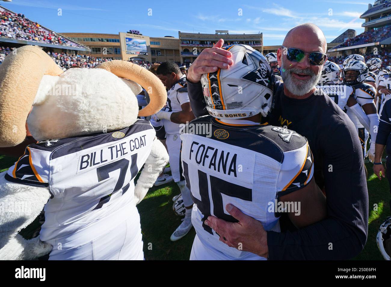 Navy head coach Brian Newberry, right, hugs fullback Daba Fofana ...