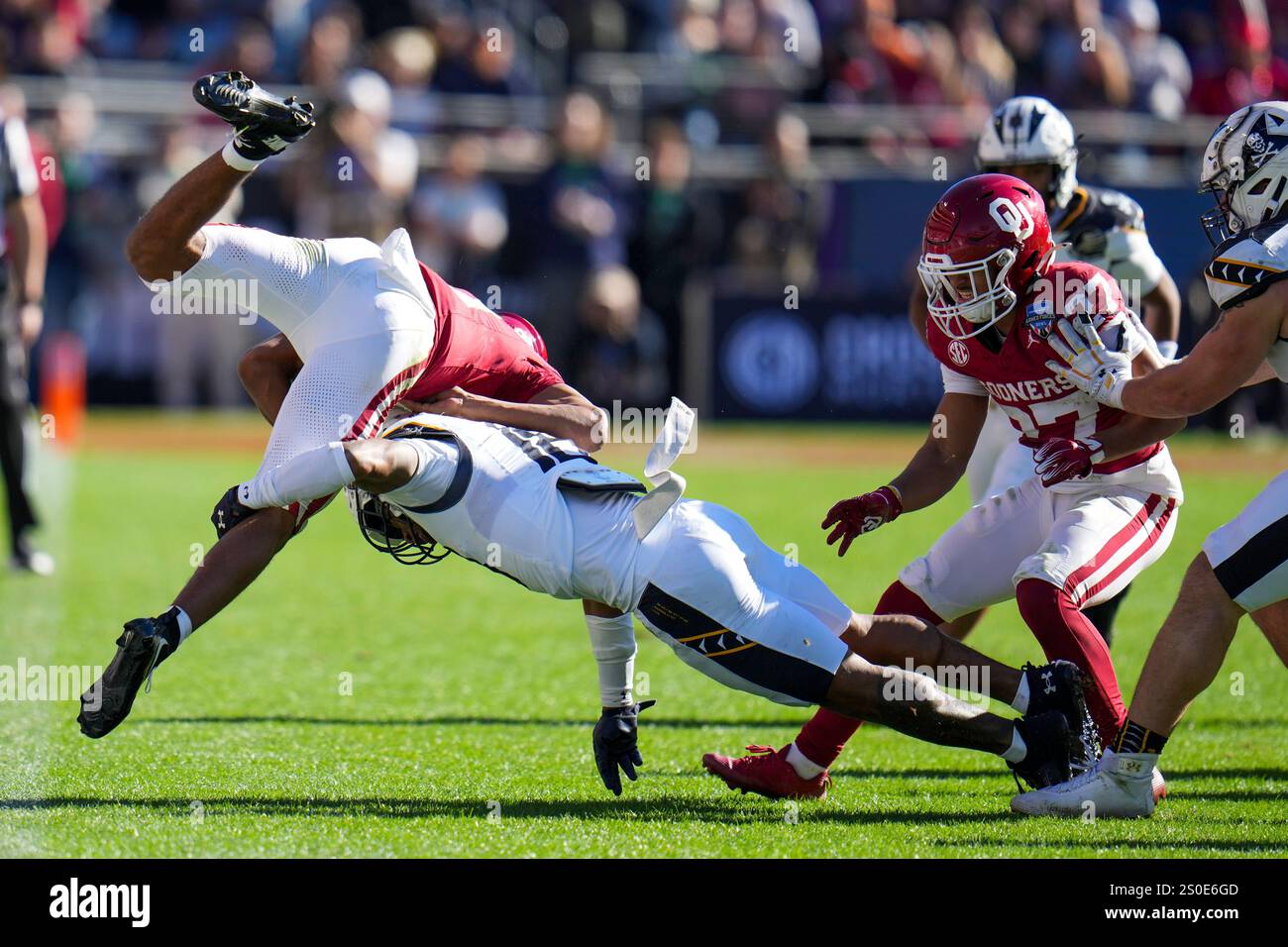 Oklahoma quarterback Michael Hawkins Jr., top, is tackled by Navy ...