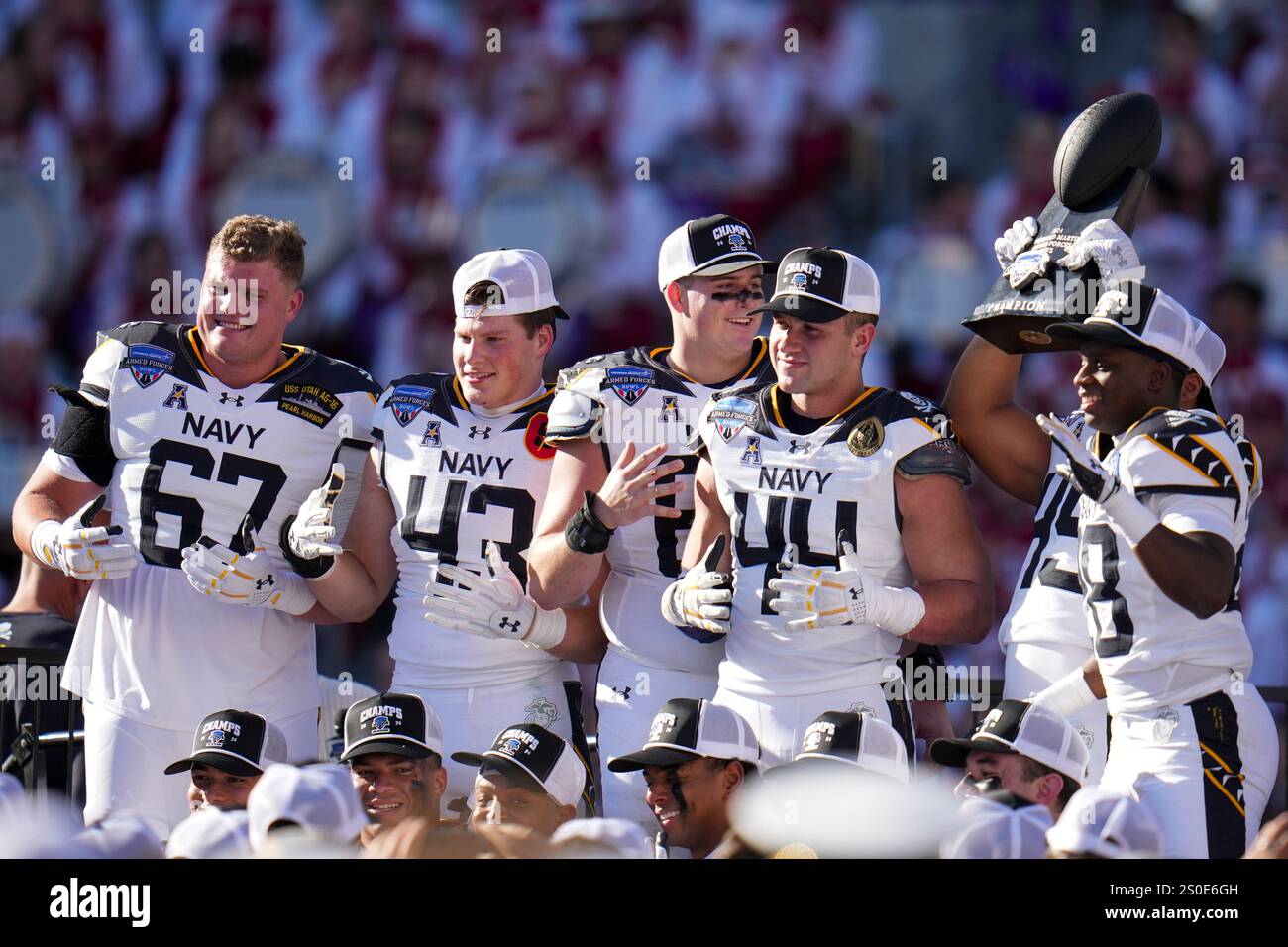 Navy players pose with the Lockheed Martin Armed Forces Bowl trophy following the Armed Forces ...
