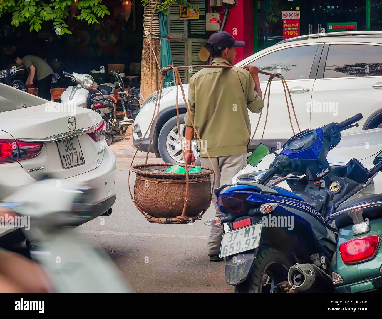 12 27 2024 - Hanoi, Vietnam. Vietnamese street vendor. Man walking with ...