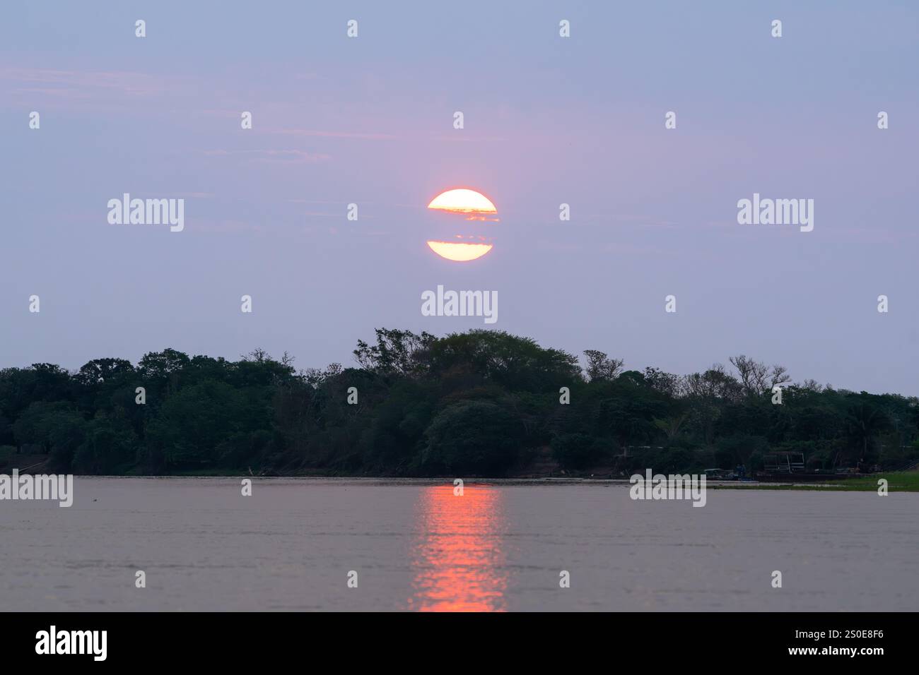 Glow of setting sun through smoke haze create leading light trail Stock ...