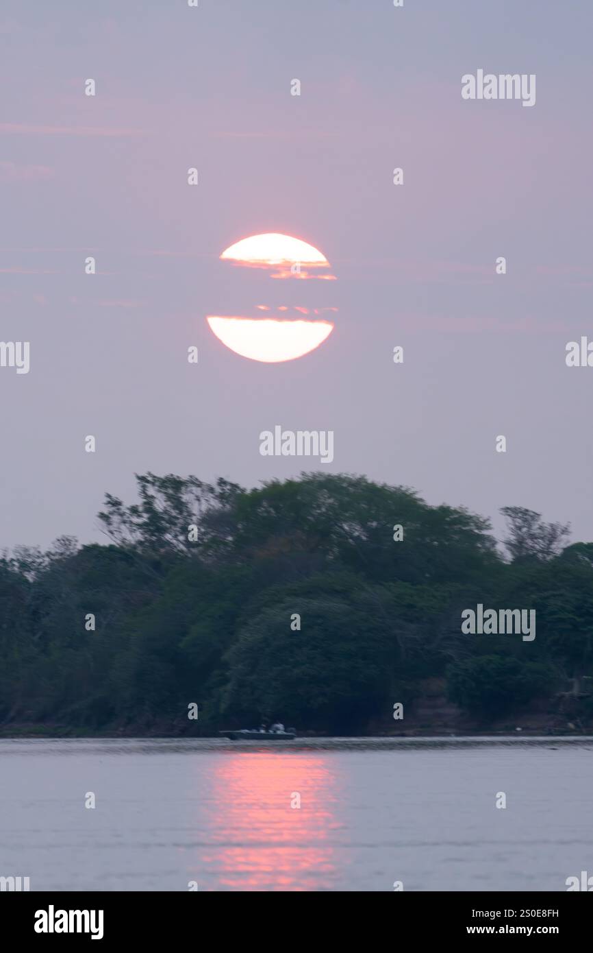 Glow of setting sun through smoke haze creates lred eating line ...