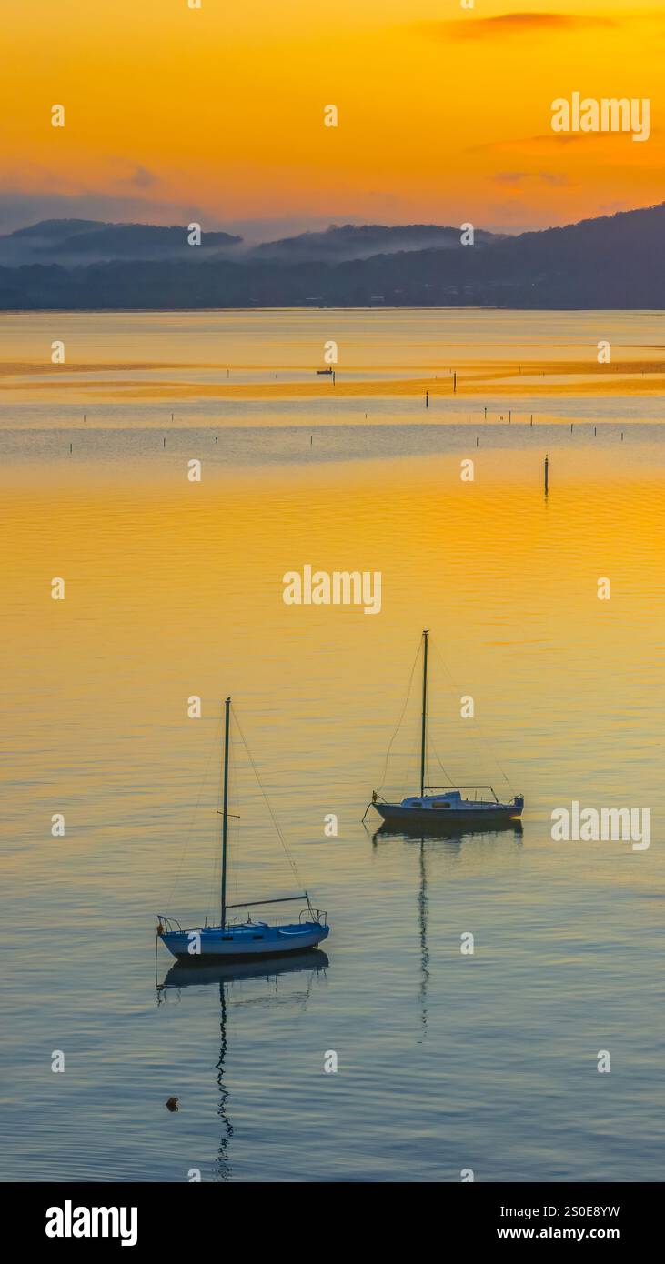 Aerial sunrise waterscape with boats, reflections and some fog around ...