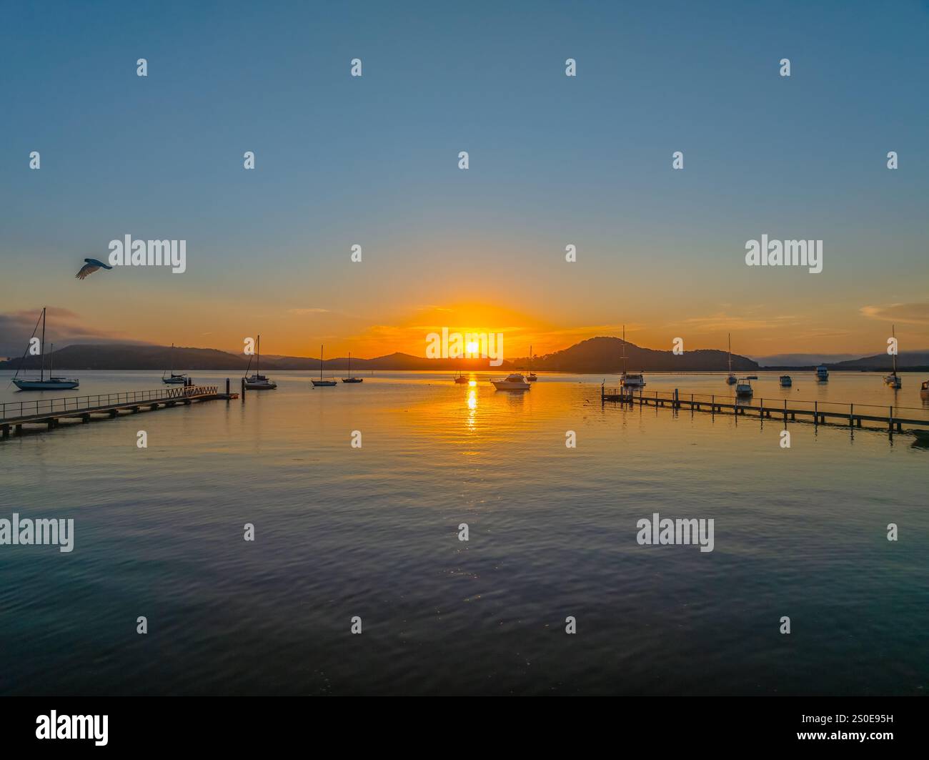 Aerial sunrise waterscape with boats, reflections and some fog around ...