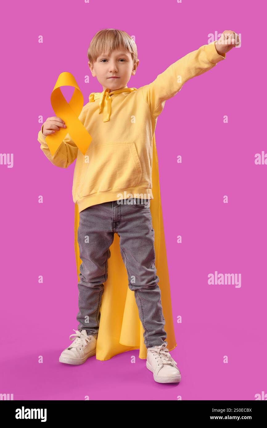 Cute little boy in superhero costume with yellow ribbon on purple ...