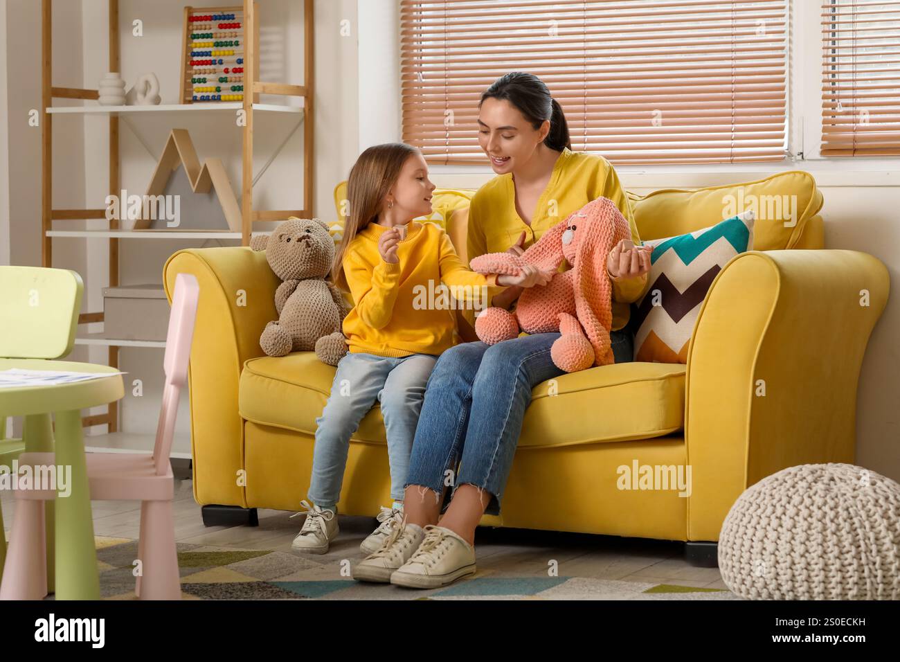 Female speech therapist with toy bunny and cute little girl pronouncing ...