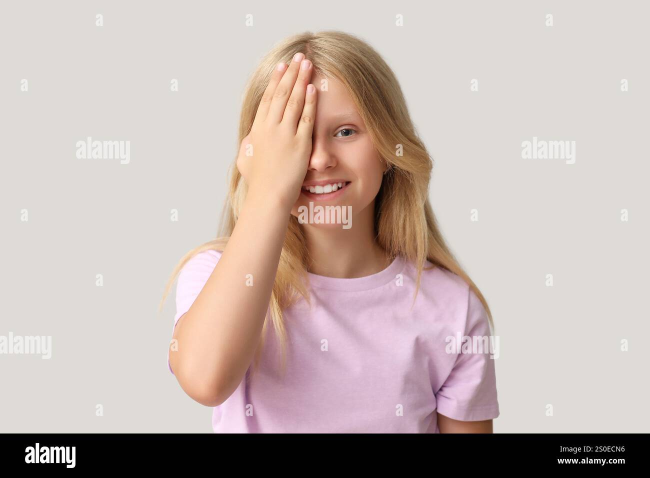Teenage girl checking her eyesight on light background. Children's Eye ...