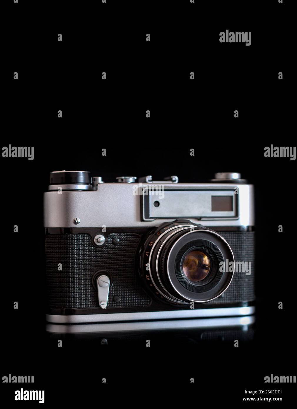 Vintage film camera on a black background, classic design, silver and ...