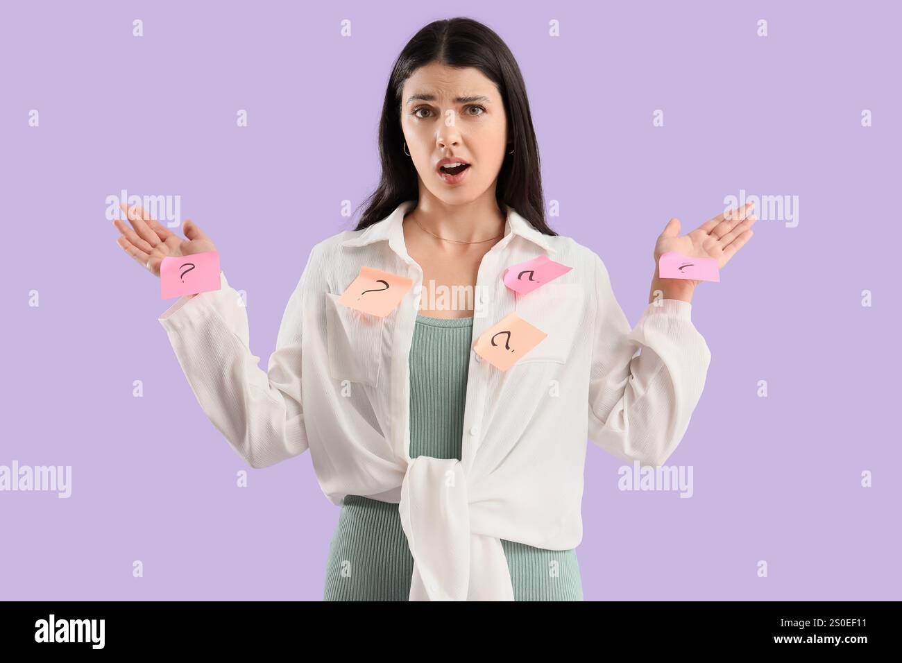Shocked young woman and sticky notes with question marks on lilac ...