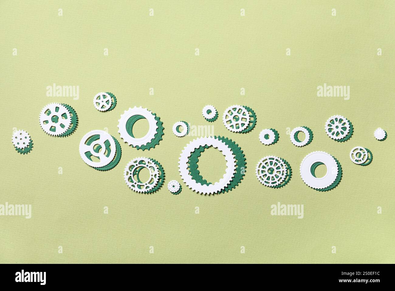 Different paper gears on green background Stock Photo - Alamy