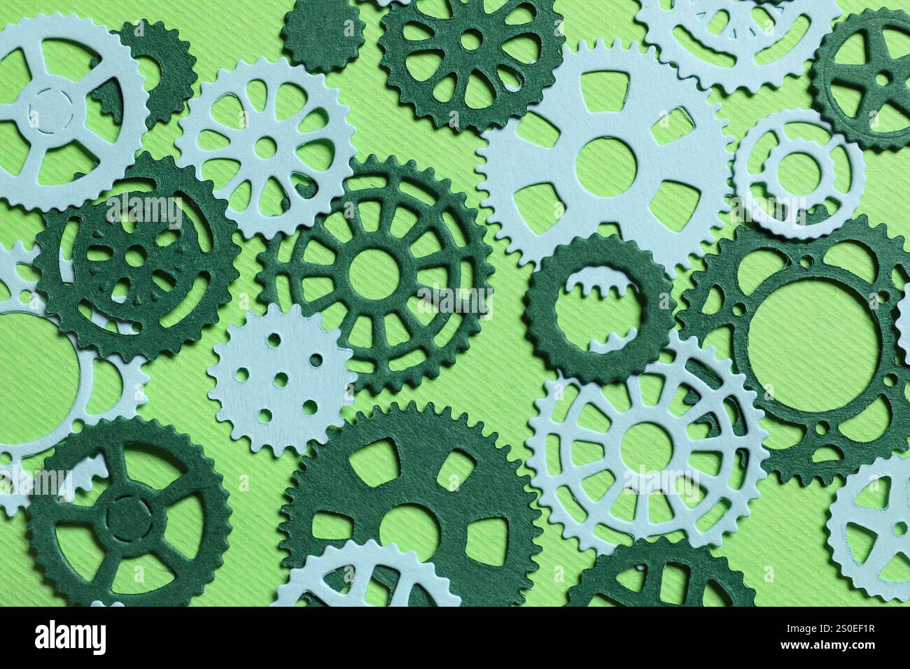 Different paper gears on green background Stock Photo - Alamy