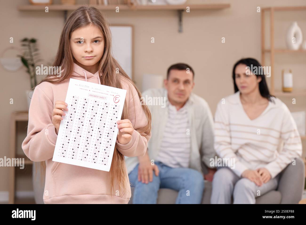 Sad girl with results of school test and her parents at home Stock ...