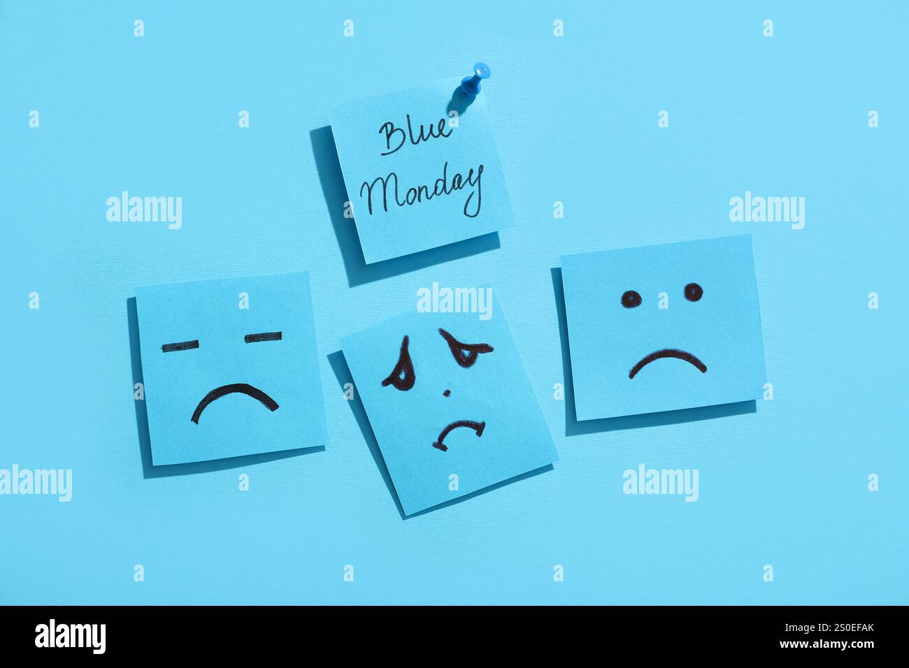 Paper sheets with drawn sad faces and text BLUE MONDAY Stock Photo - Alamy
