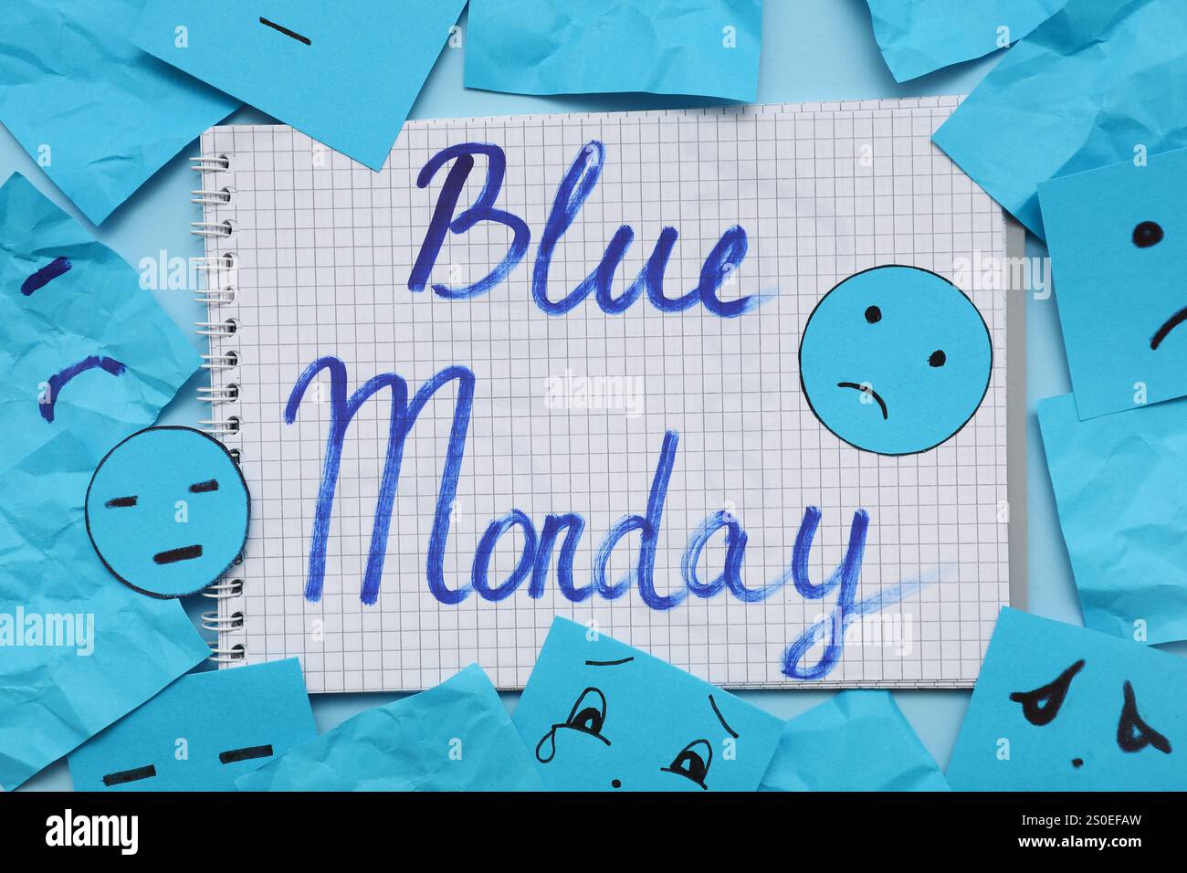 Notebook with written text BLUE MONDAY and paper sheets with drawn sad ...