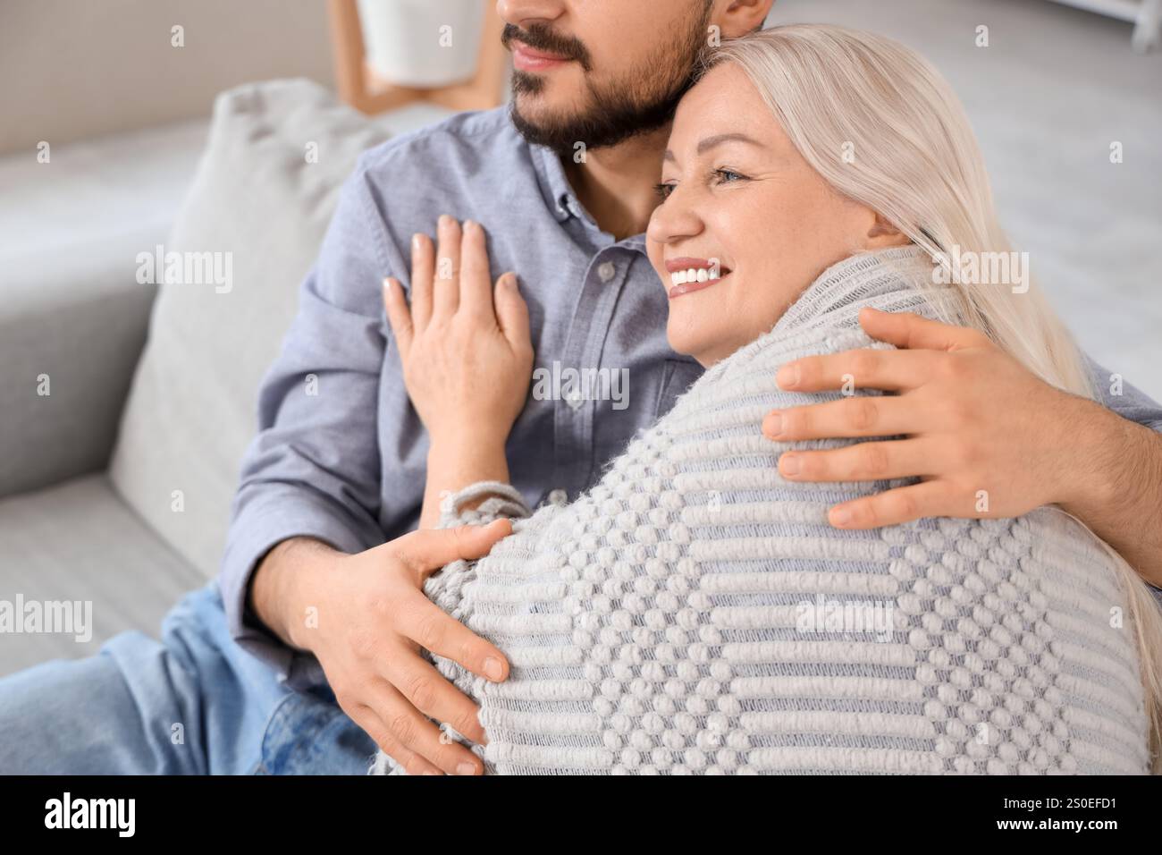 Young man hugging his mother with plaid at home, closeup Stock Photo ...