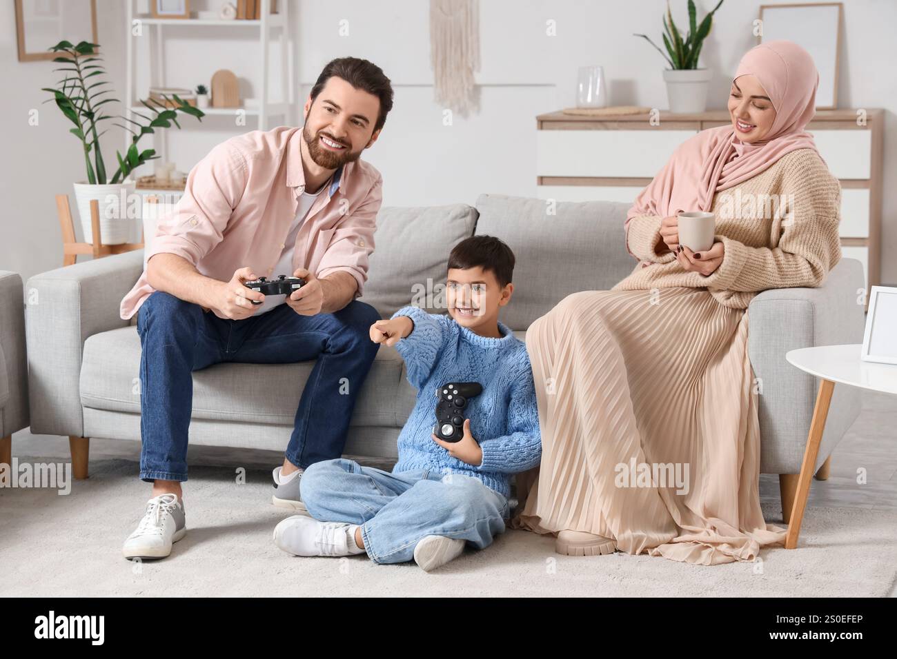 Happy Muslim family playing video game at home Stock Photo - Alamy