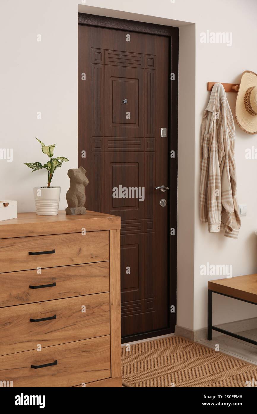 Interior of hallway with door, rack and commode Stock Photo - Alamy