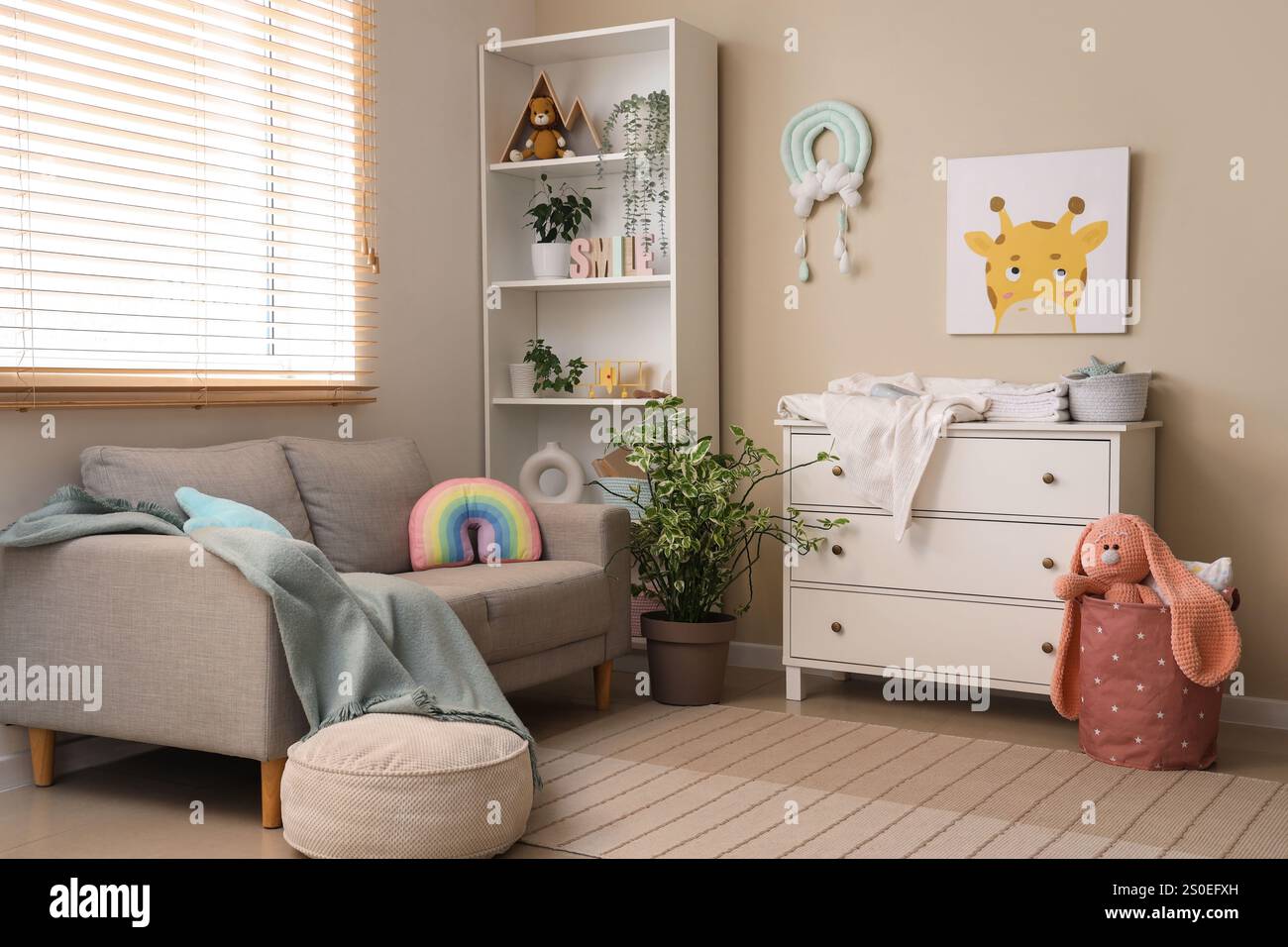 Interior of nursery with commode, shelf unit and sofa Stock Photo - Alamy