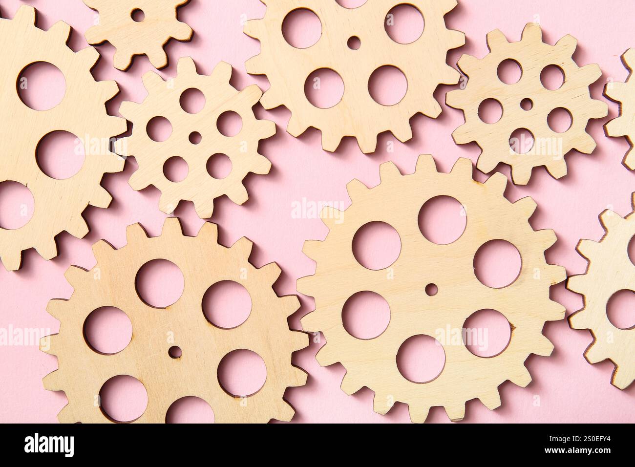 Wooden gears on pink background Stock Photo - Alamy