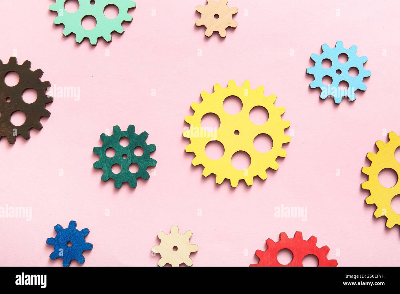 Wooden gears on pink background Stock Photo - Alamy