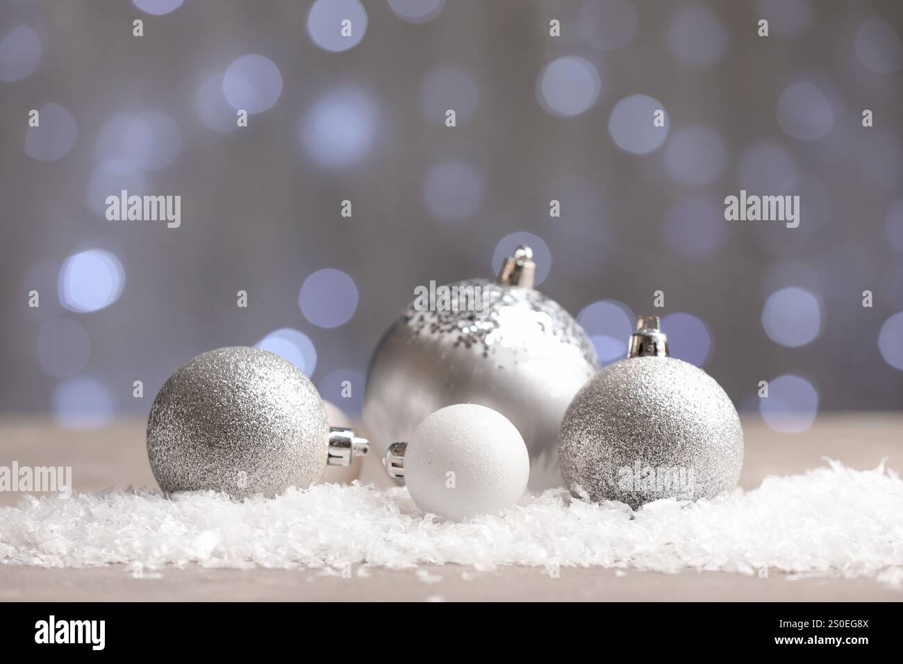Christmas balls with snow on table against blurred lights Stock Photo ...