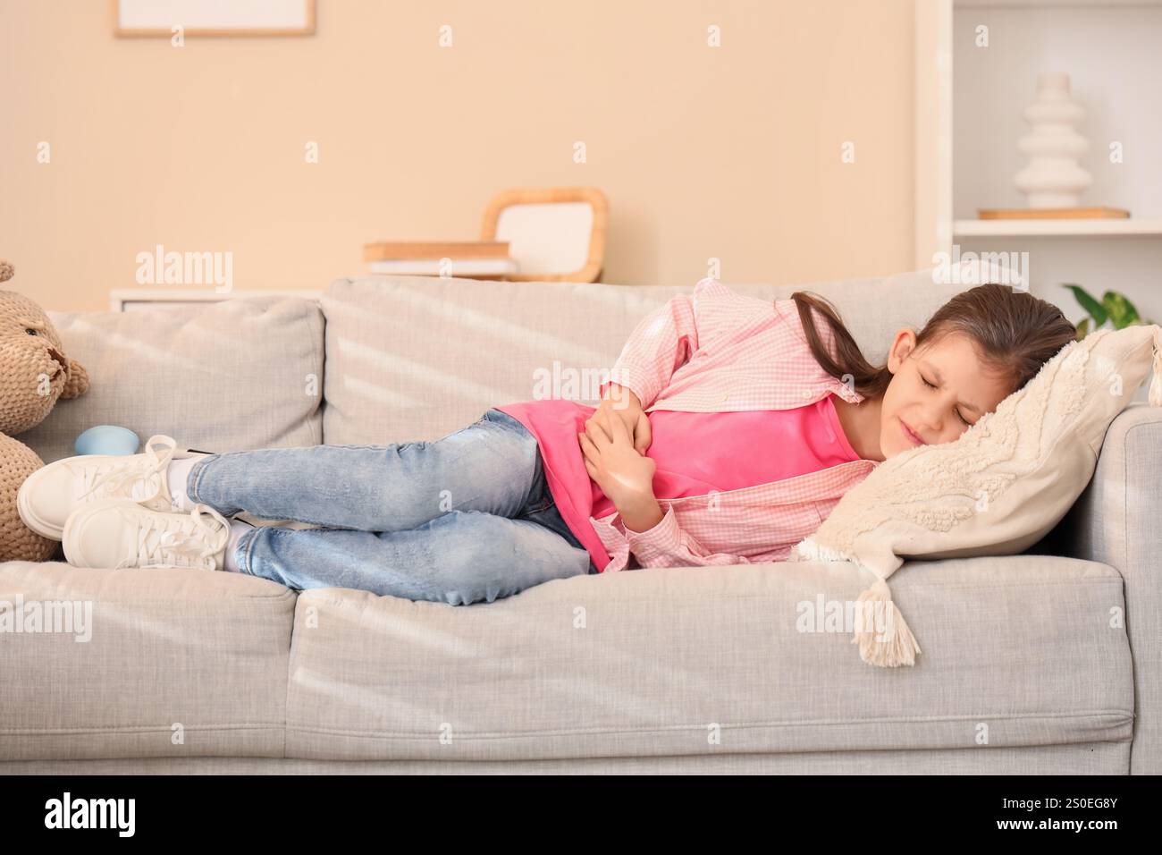 Teenage girl with appendicitis lying on sofa at home Stock Photo - Alamy