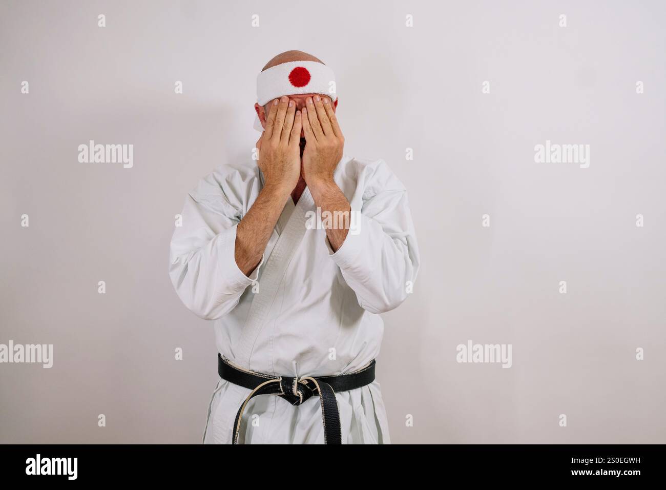 Disappointed karateka in gi hides his face Stock Photo - Alamy