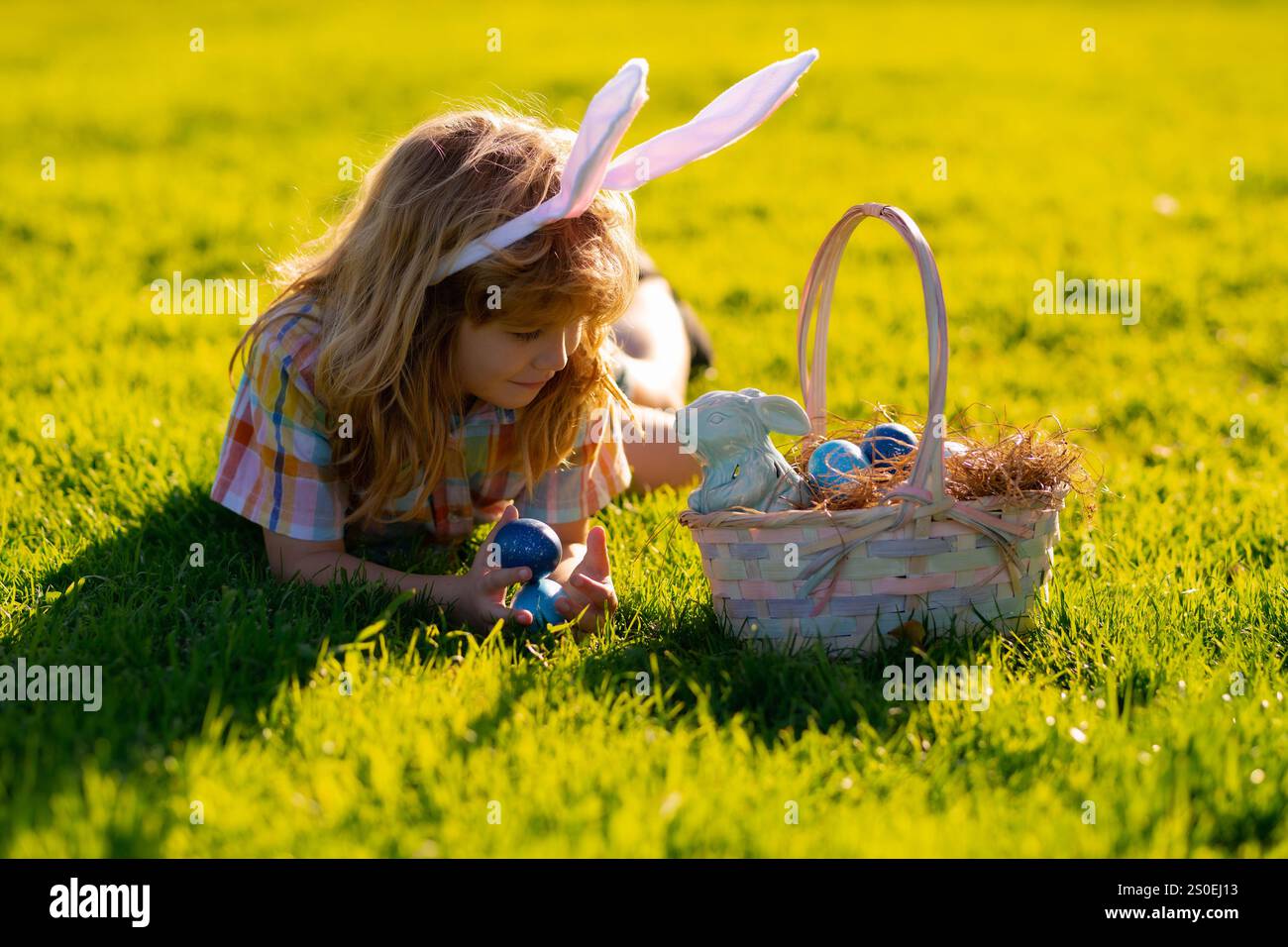 Easter kid in park. Child boy hunting easter eggs. Cute kid in rabbit ...