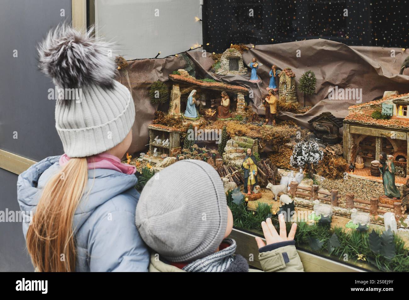 The kids looking at a Christmas nativity scene with baby Jesus Creche ...