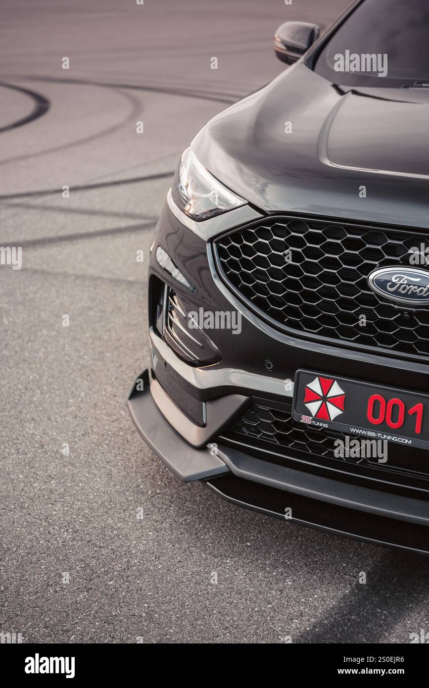 Black Ford Edge ST in parking lot at sunset. Front right corner view of ...