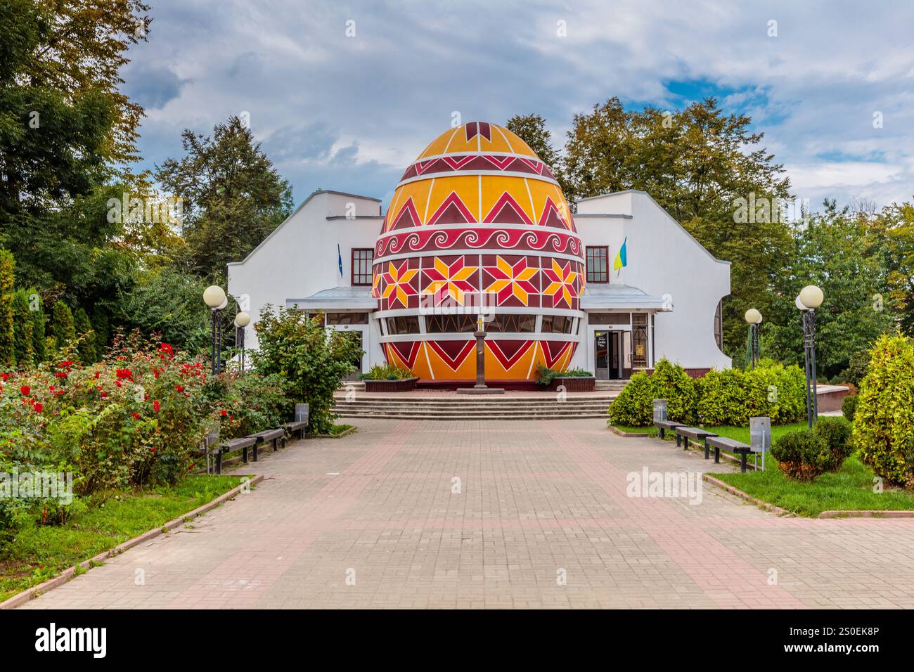 A large, colorful egg-shaped building with a white roof. The building ...
