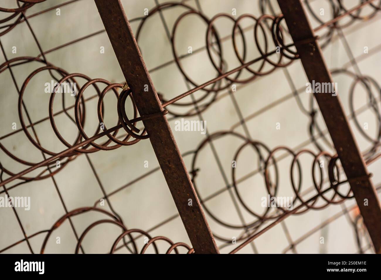 A metal frame with many springs and a wire mesh. The springs are ...