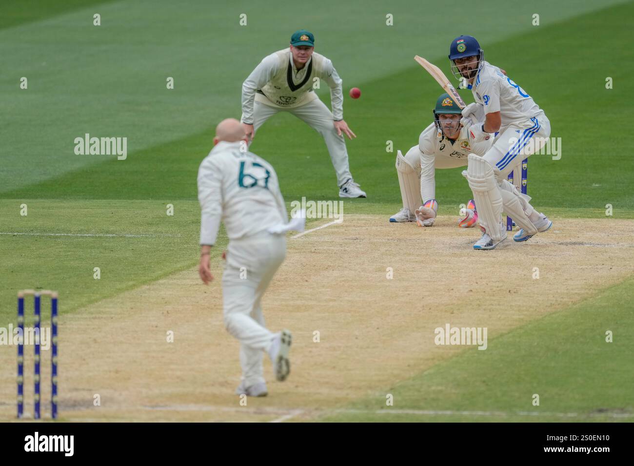Australia's Nathan Lyon, left, bowls a delivery to India's Nitish Kumar ...